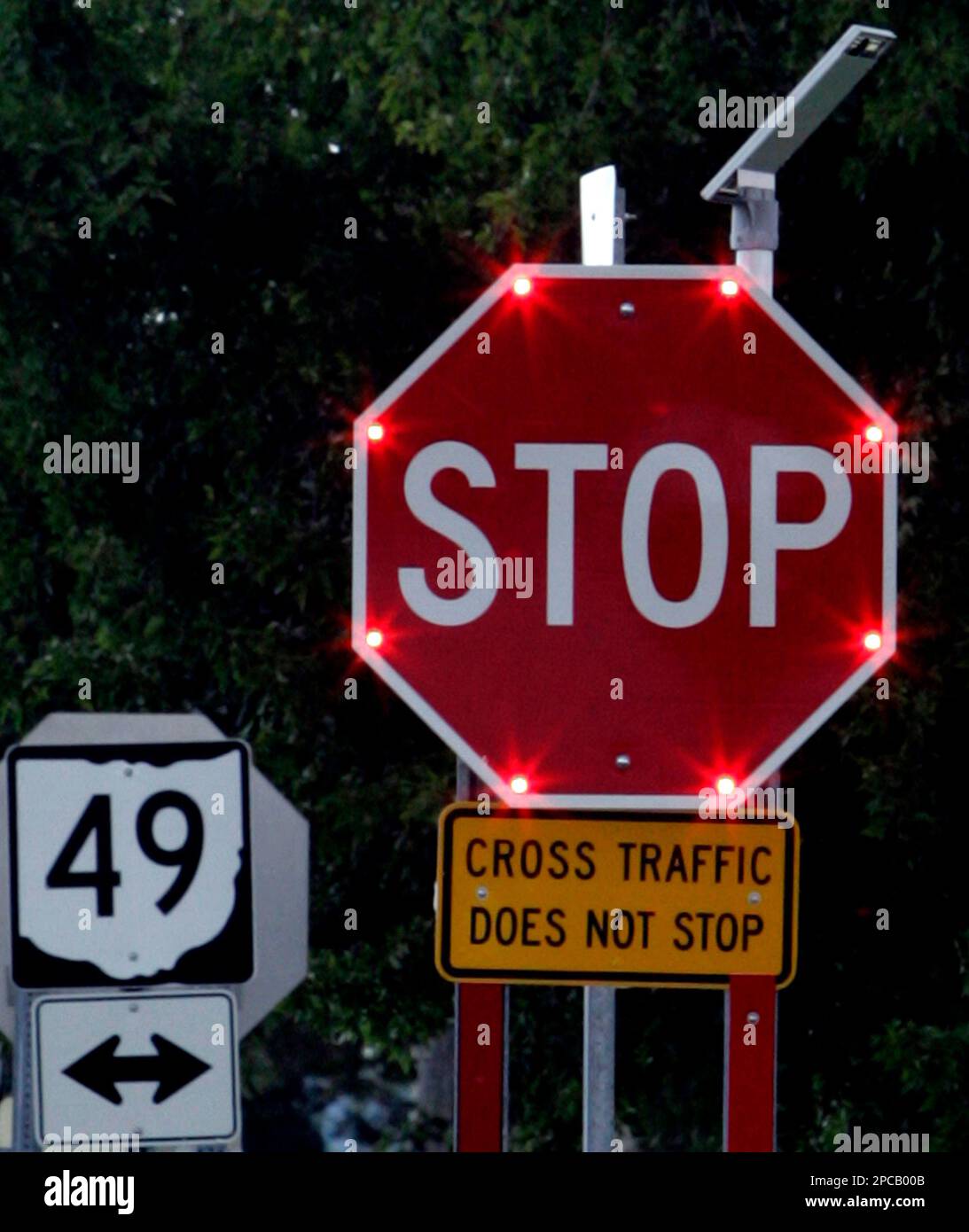 A red light flashes on each corner of this stop sign at the ...