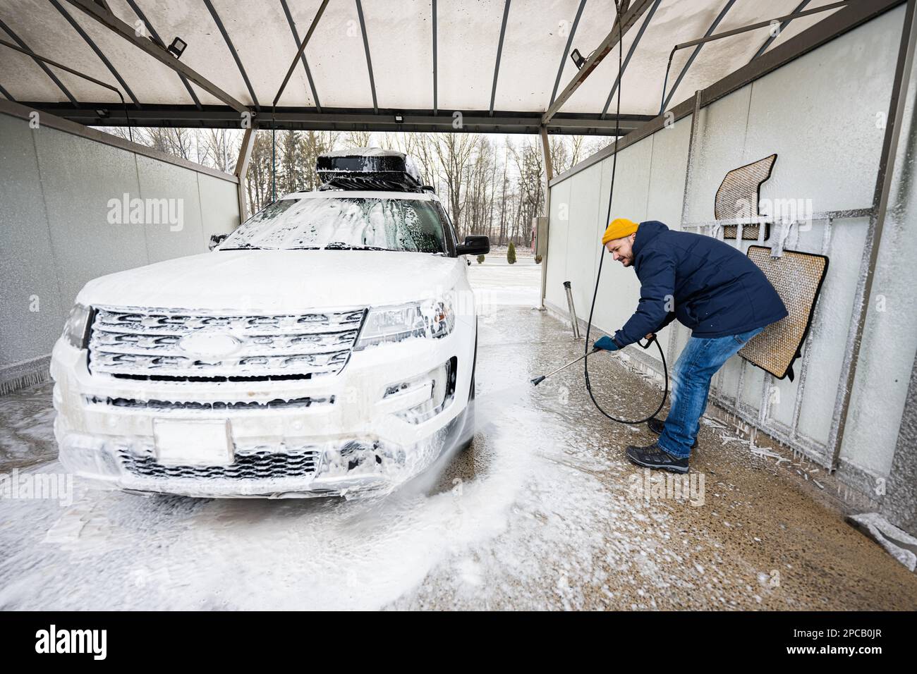 Man washing high pressure water american SUV car with roof rack at self ...