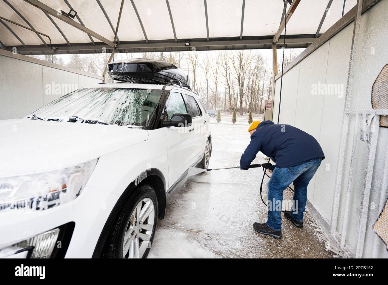 Man washing high pressure water american SUV car with roof rack at self ...