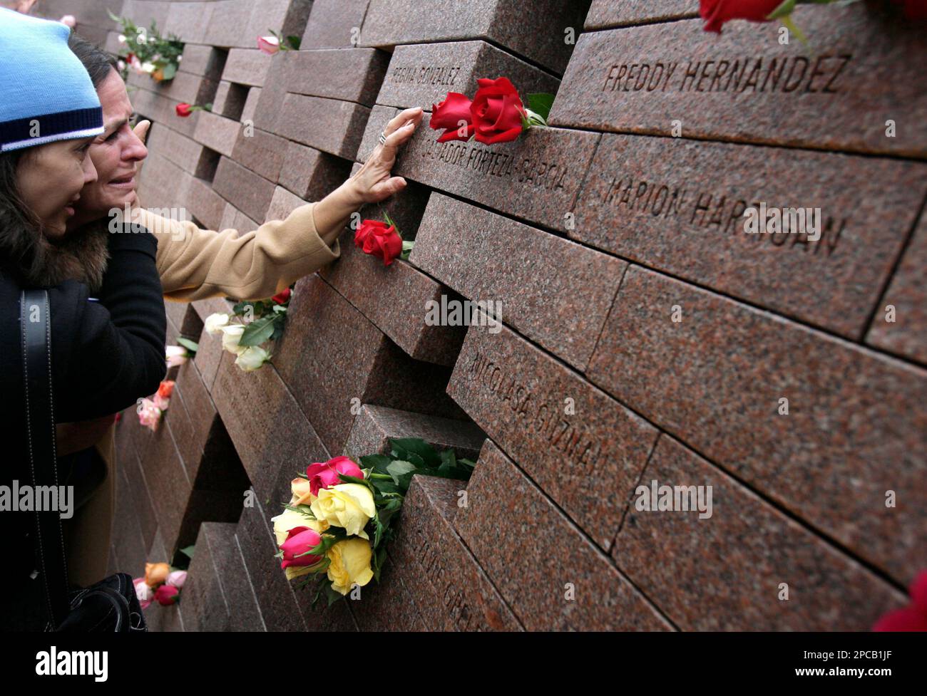 Nannette Forteza, second from left, is comforted by a friend while ...