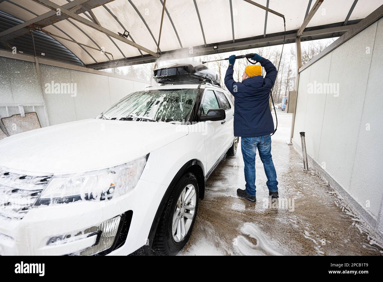Man washing high pressure water american SUV car with roof rack at self ...
