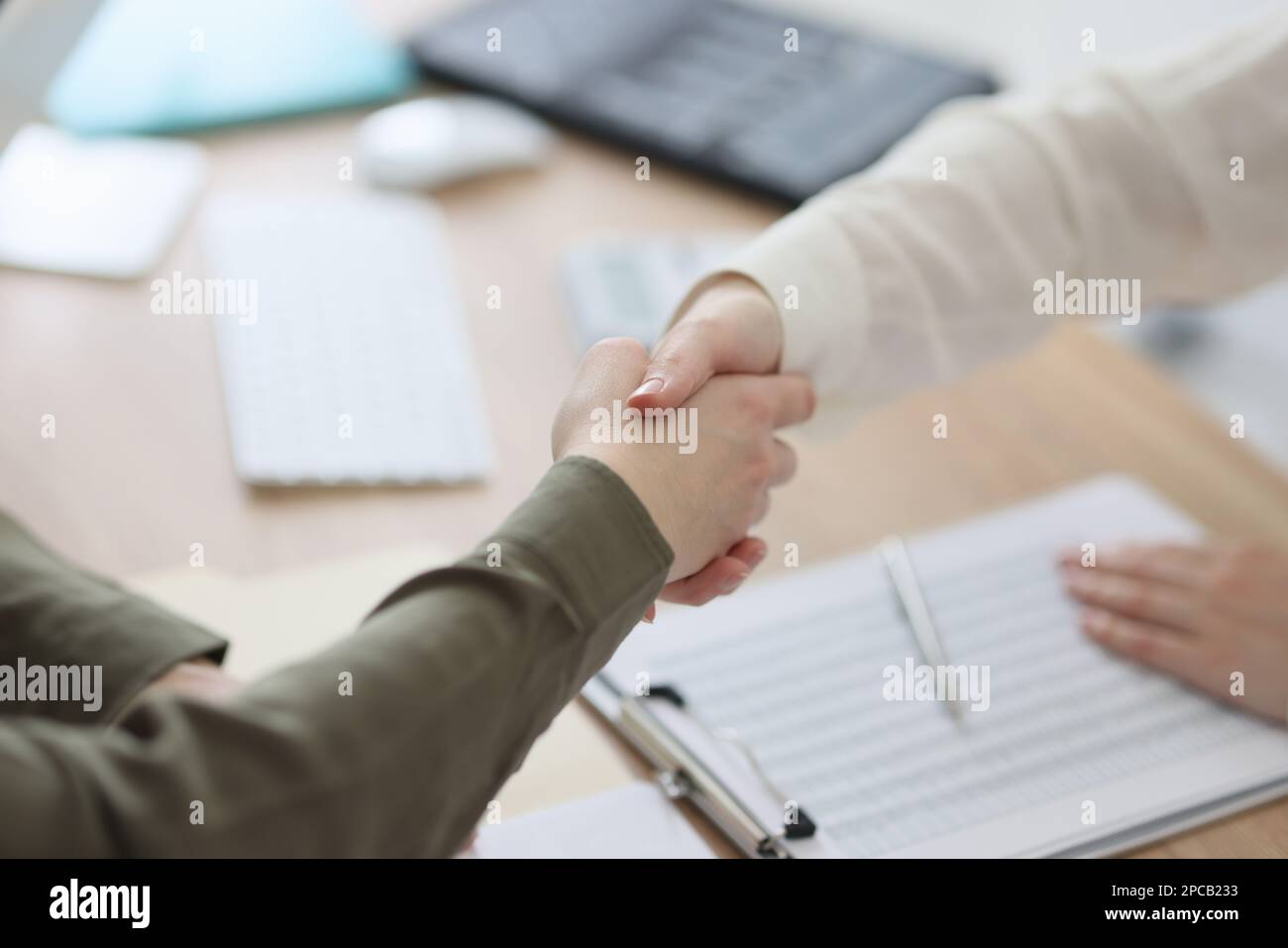Close-up of handshake over office desk Stock Photo - Alamy