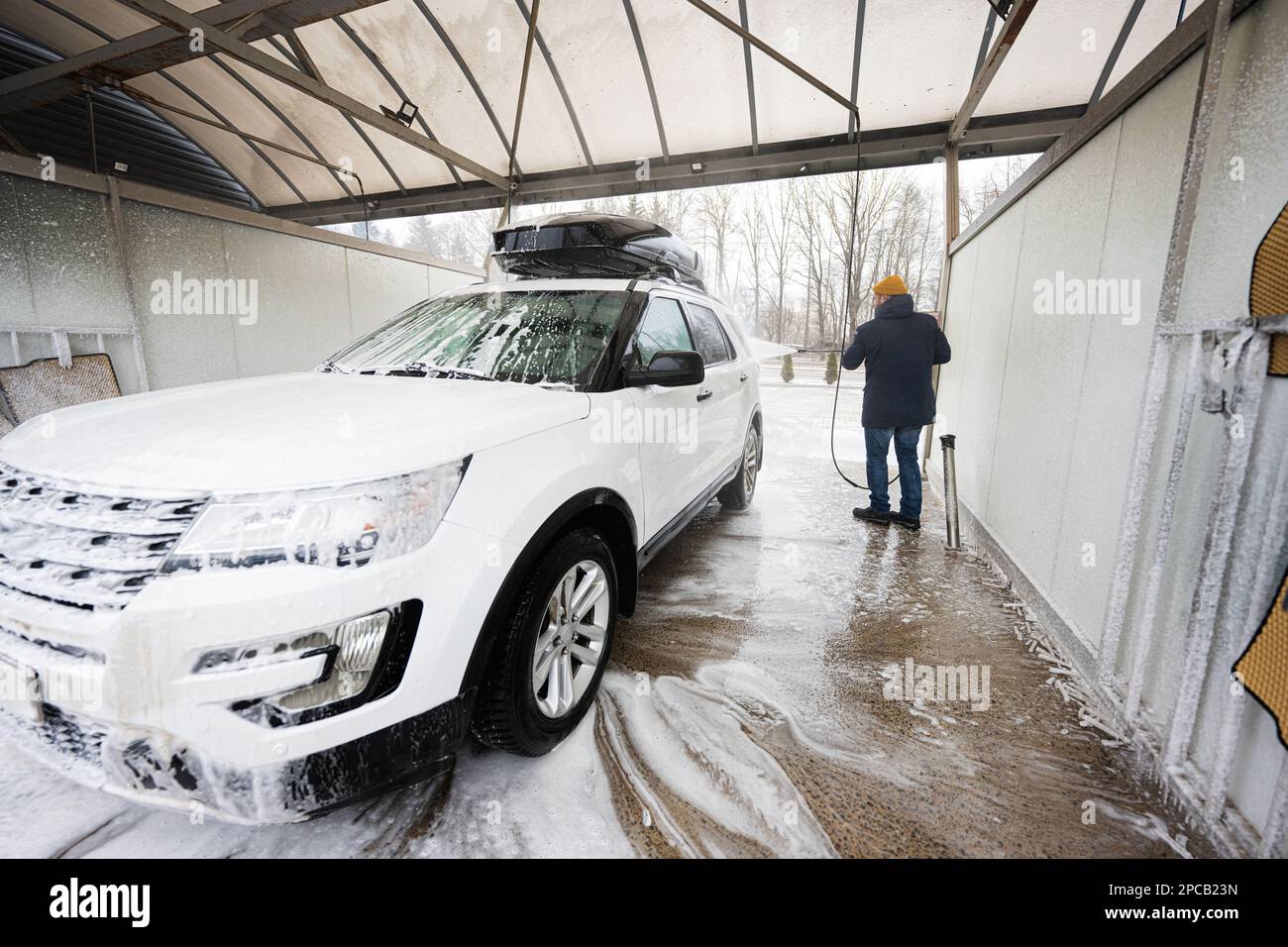 Man washing high pressure water american SUV car with roof rack at self ...