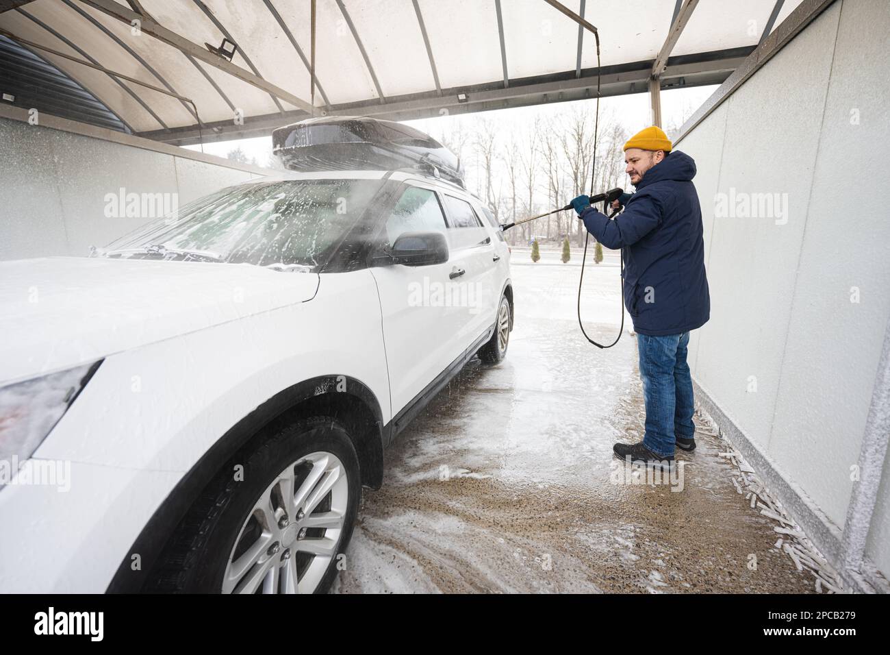 Man washing high pressure water american SUV car with roof rack at self ...