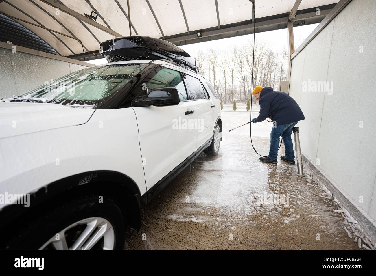 Man washing high pressure water american SUV car with roof rack at self ...