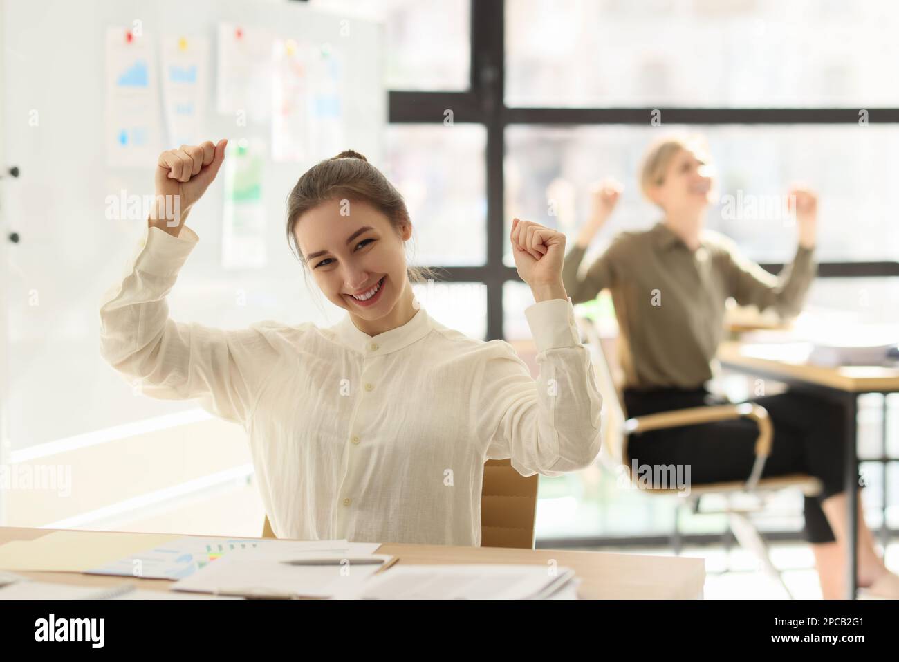 Managers raise their hands up and celebrate at workplaces in office ...