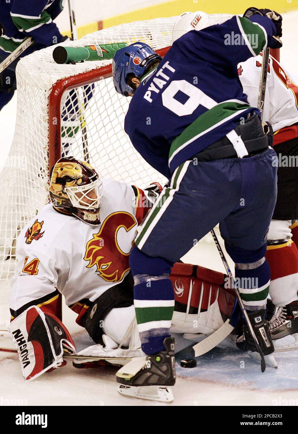 Vancouver Canucks' Taylor Pyatt (9) attempts to dig the puck out from ...