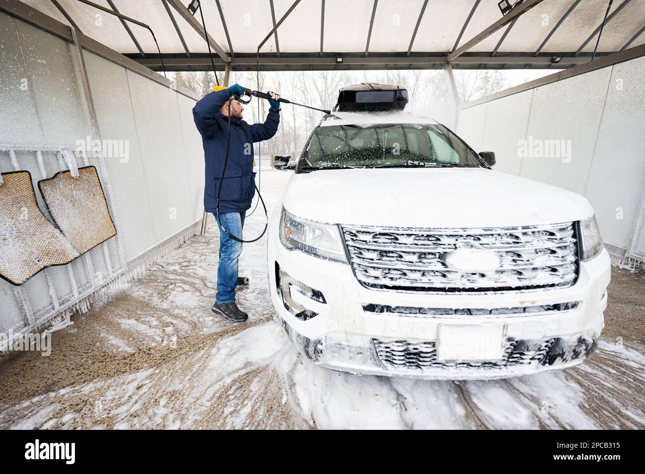 Man washing high pressure water american SUV car with roof rack at self ...
