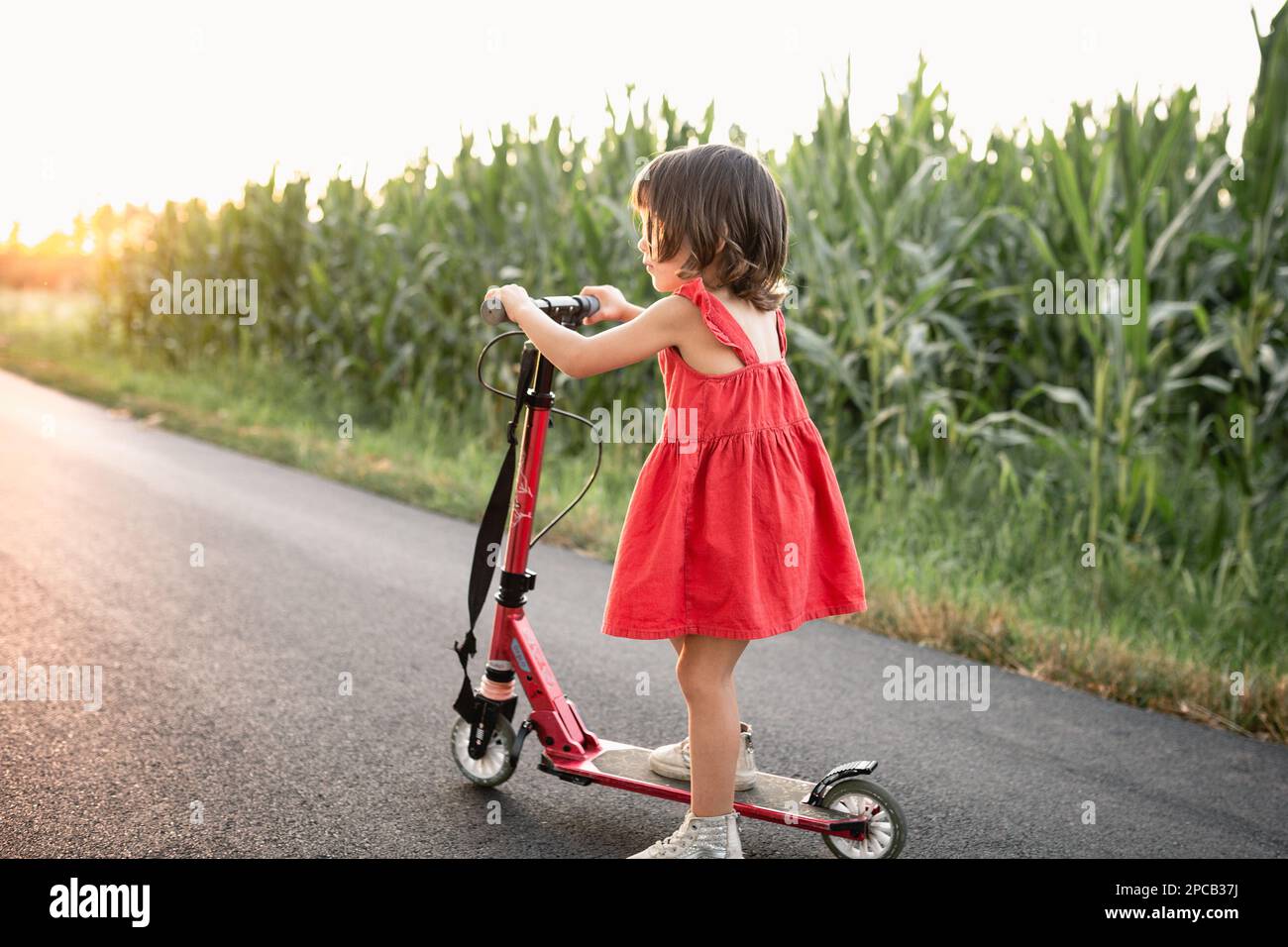 Child playing in road with scooter hi-res stock photography and images ...