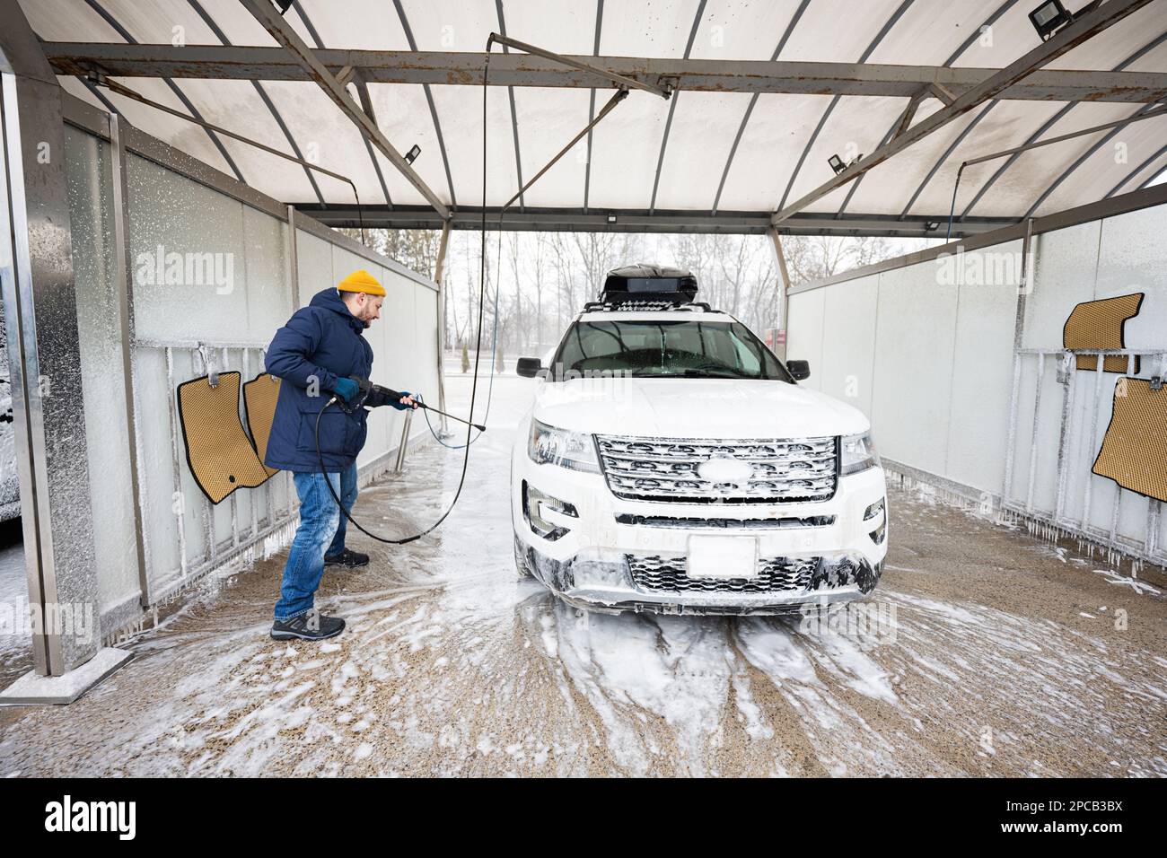 Man washing high pressure water american SUV car with roof rack at self ...