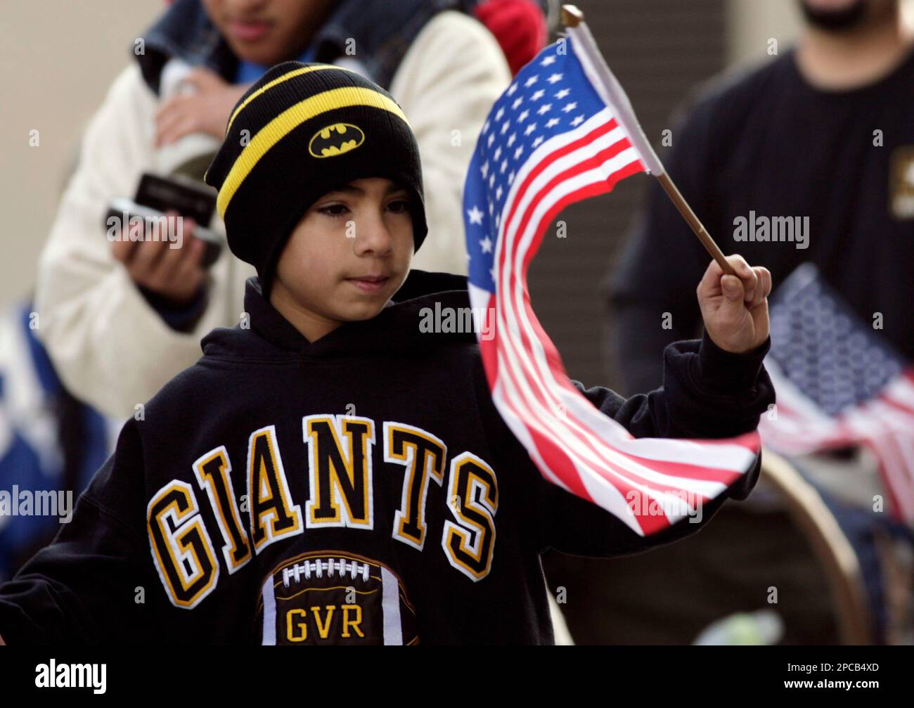 Seven-year-old Israel Rodriguez waves a U.S. flag while marching with ...