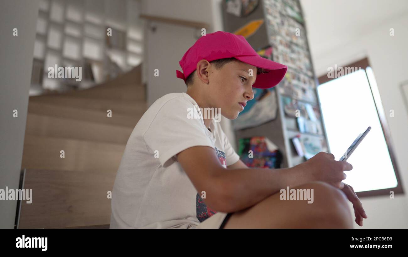 One young boy scrolling social media on smartphone device at home ...