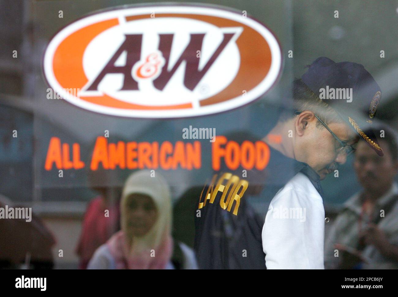 A member of Indonesian Police Forensic Unit inspects an A&W restaurant ...