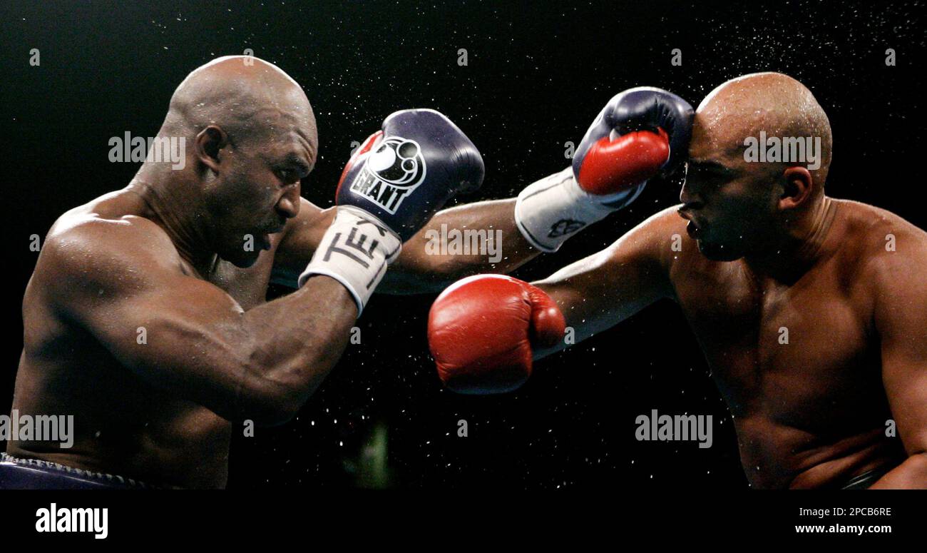 Evander Holyfield, left, lands a punch to the head of Fres Oquendo ...