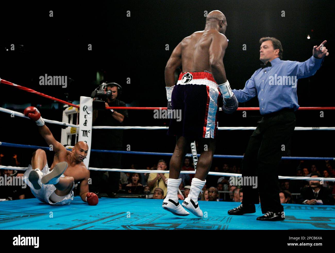 Evander Holyfield, center, is sent to a corner after he knocked down ...