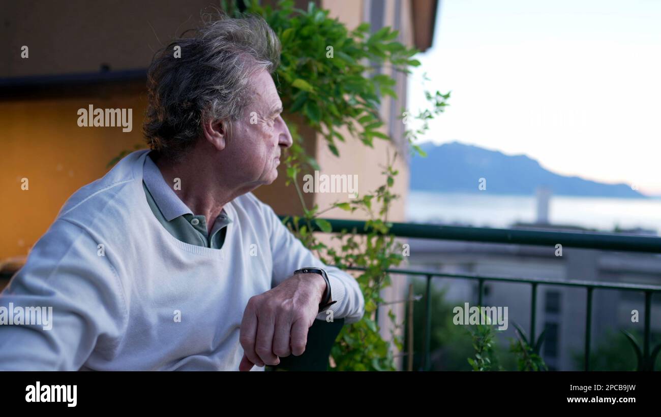 One pensive senior man looking at scenic landscape during sunset time ...