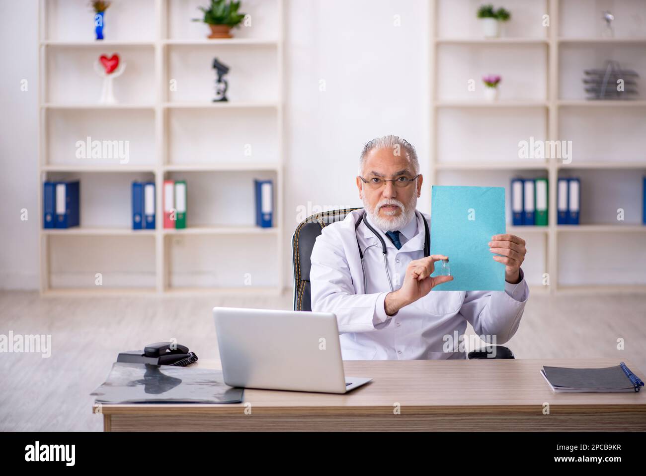 Old male doctor working at the hospital Stock Photo - Alamy