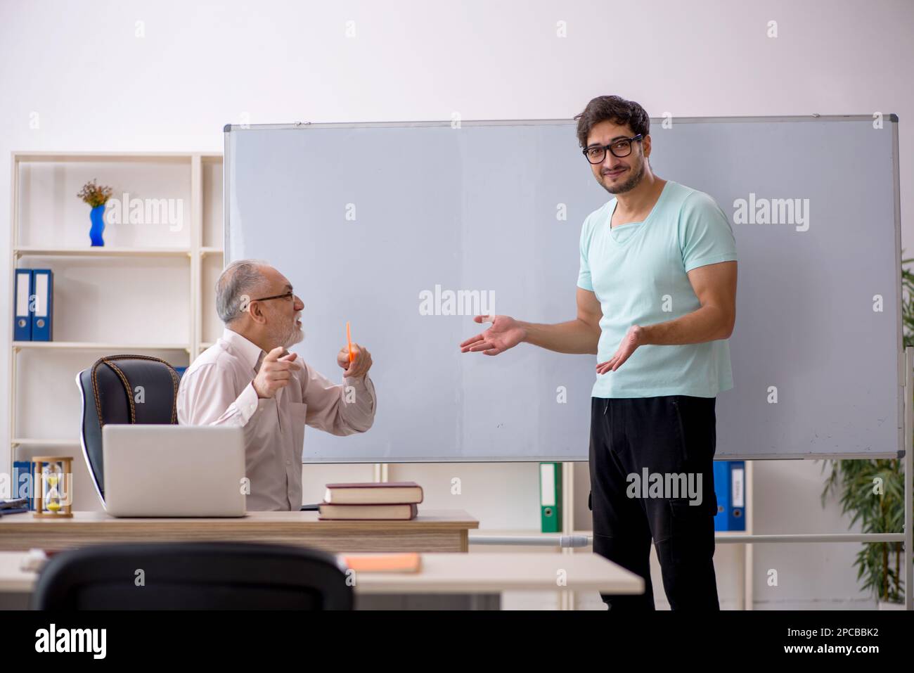 Old teacher and young student in the classroom Stock Photo - Alamy