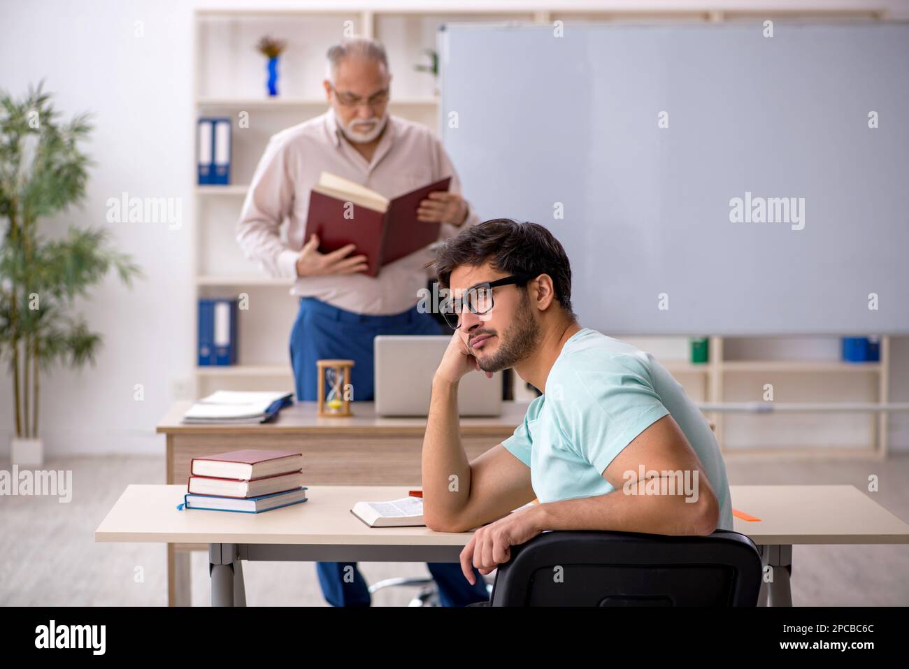 Old teacher and young student in the classroom Stock Photo - Alamy