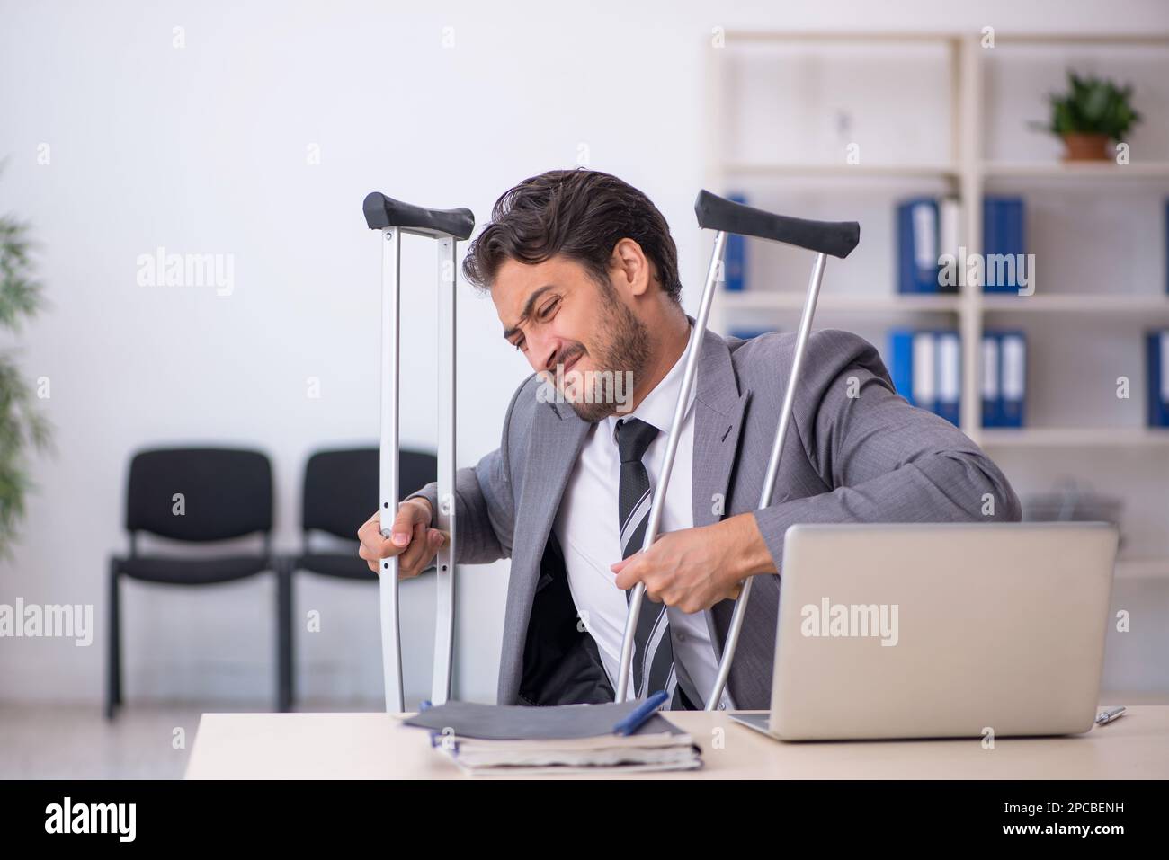 Young businessman employee after car accident working in the office ...