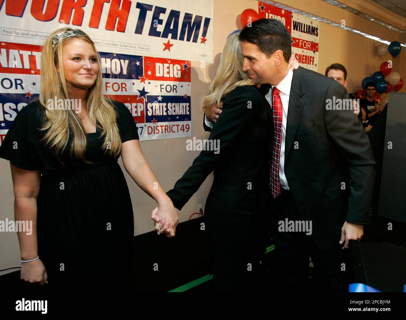 Democrat Brad Ellsworth hugs his wife, Beth as she holds the hand of ...