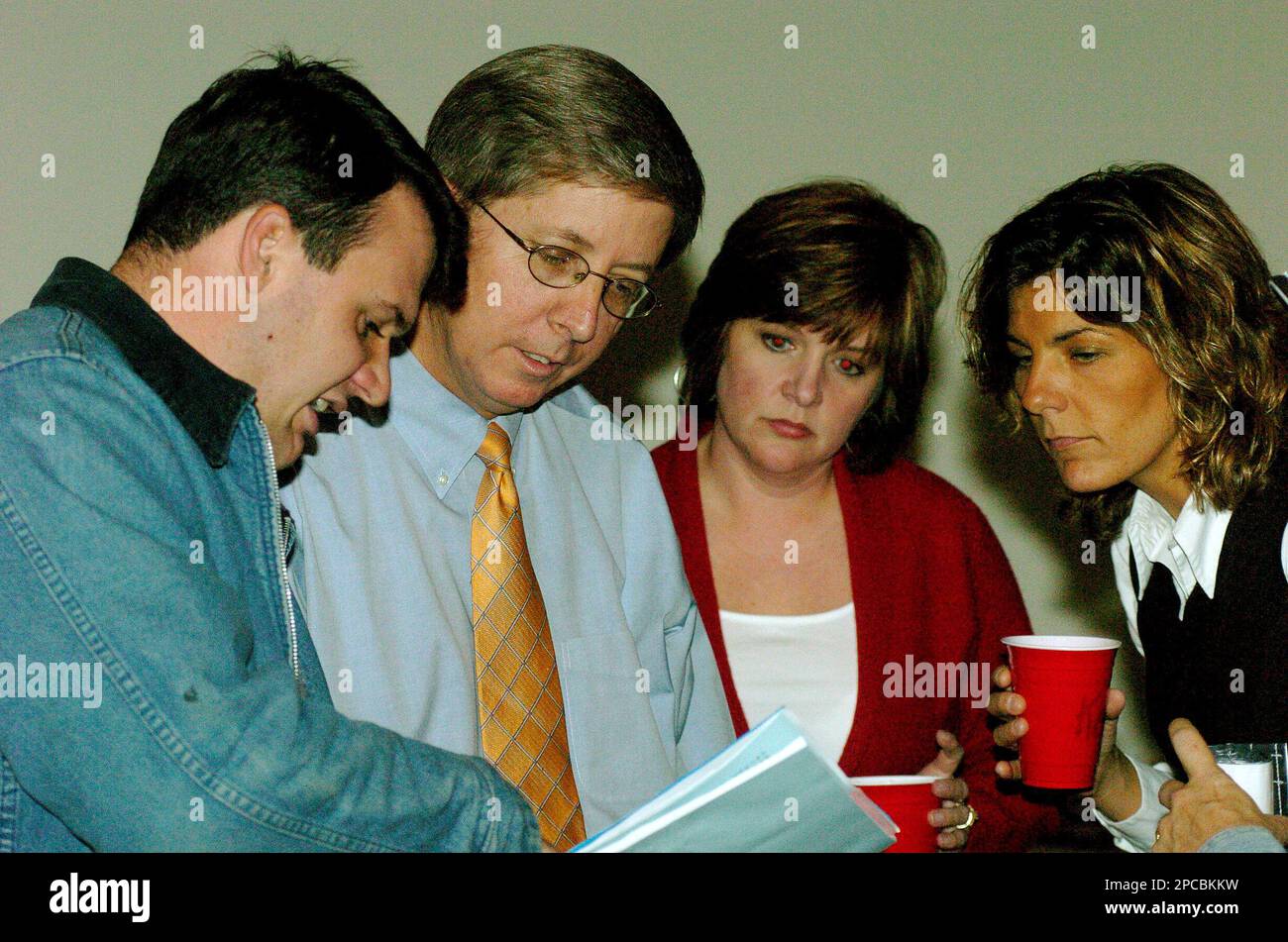 State Sen. Bob Leeper, center left, looks over results with his wife ...