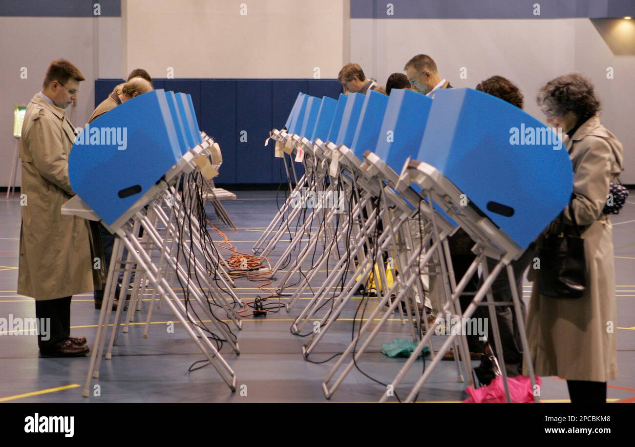 Early morning voters use electronic voting machines to cast their ...