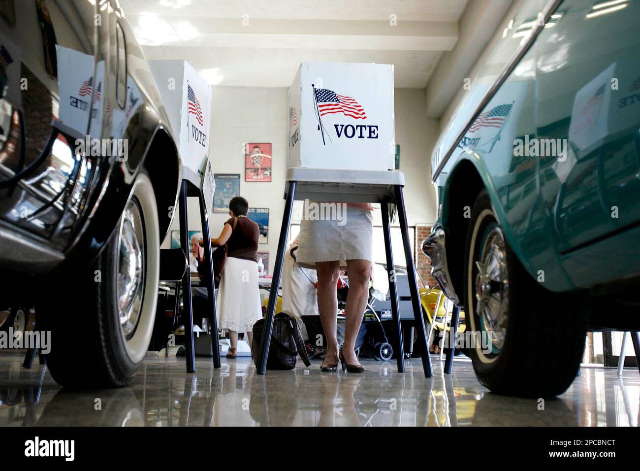 Estelle Repko, center, votes at a polling place held at a business ...