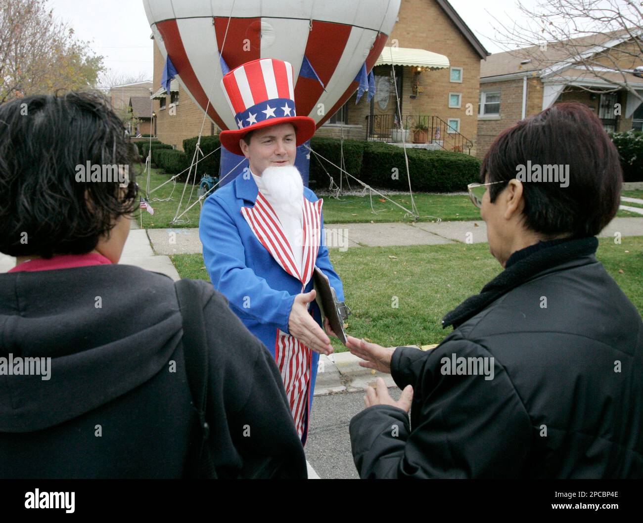 Precinct Captain Joe Lullo, dressed as Uncle Sam, greets Maria Sanchez ...