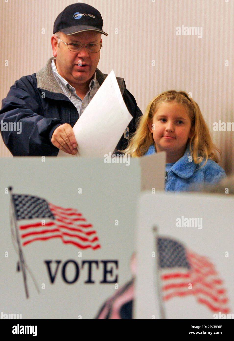 Phil Miller shows his 9-year-old stepdaughter Mary Ulman the election ...
