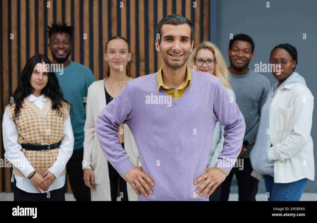 gorgeous casual man in purple shirt standing with hands on hip looking ...