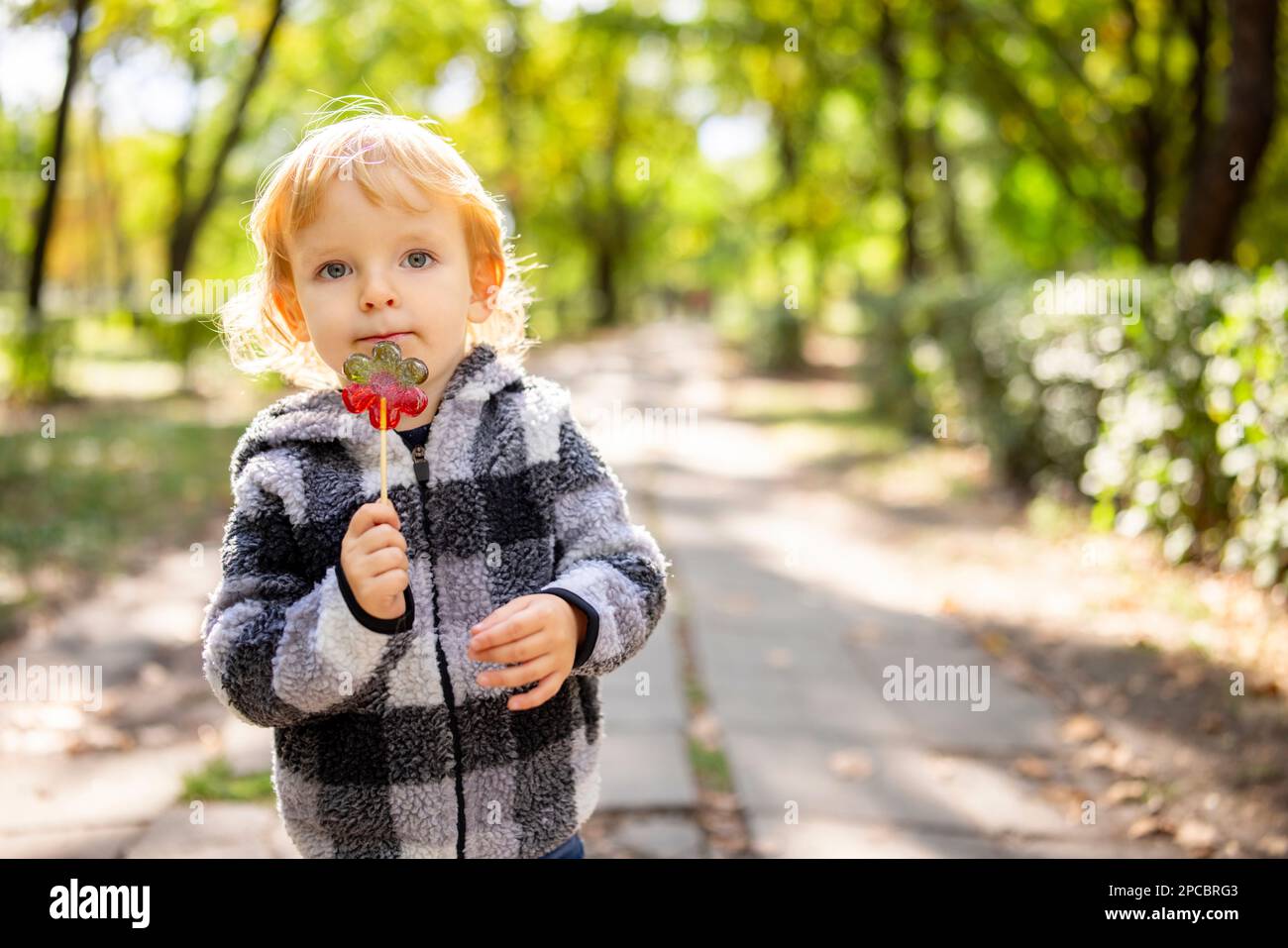 Funny child with candy lollipop, little boy eating big sugar lollipop ...