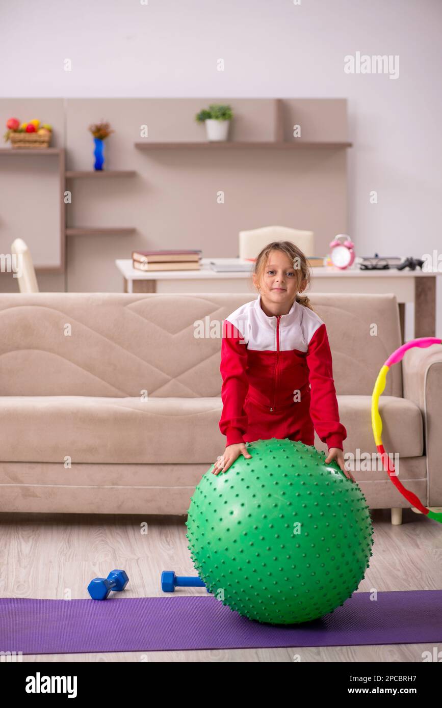 Young small girl doing sport exercises at home Stock Photo - Alamy