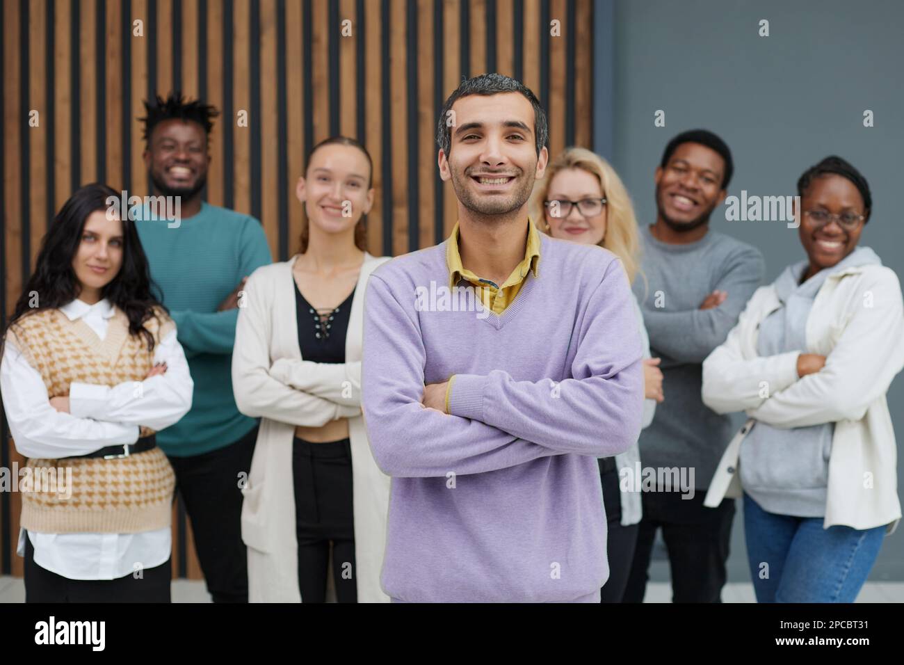 gorgeous casual man in purple shirt standing with hands on hip looking ...