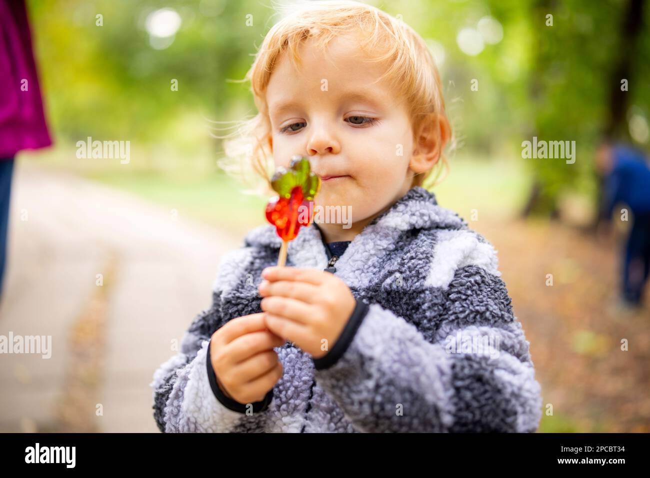 Funny child with candy lollipop, little boy eating big sugar lollipop ...