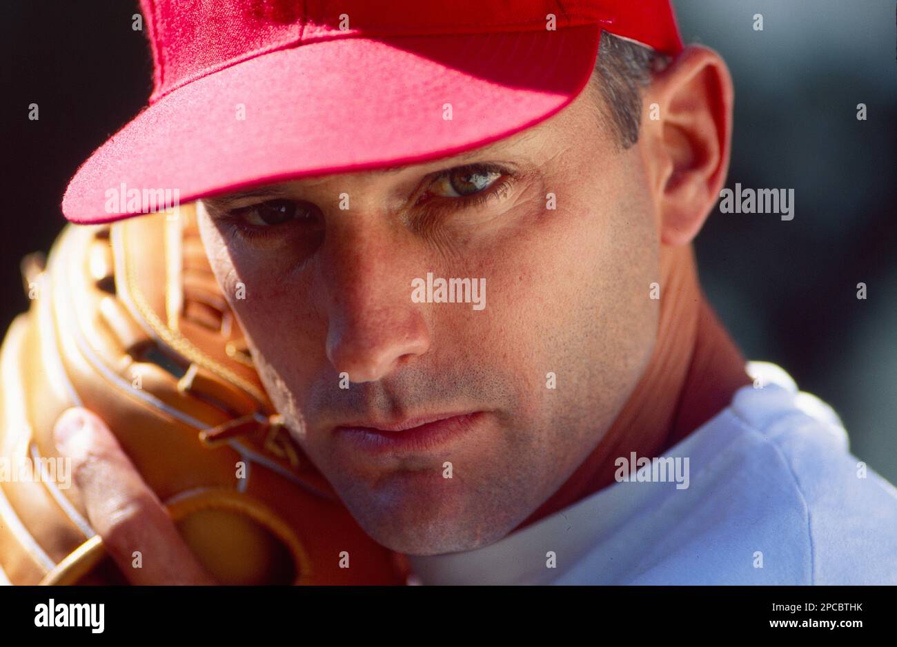 Close-up shot of a baseball pitcher in a red cap, concentrating on ...