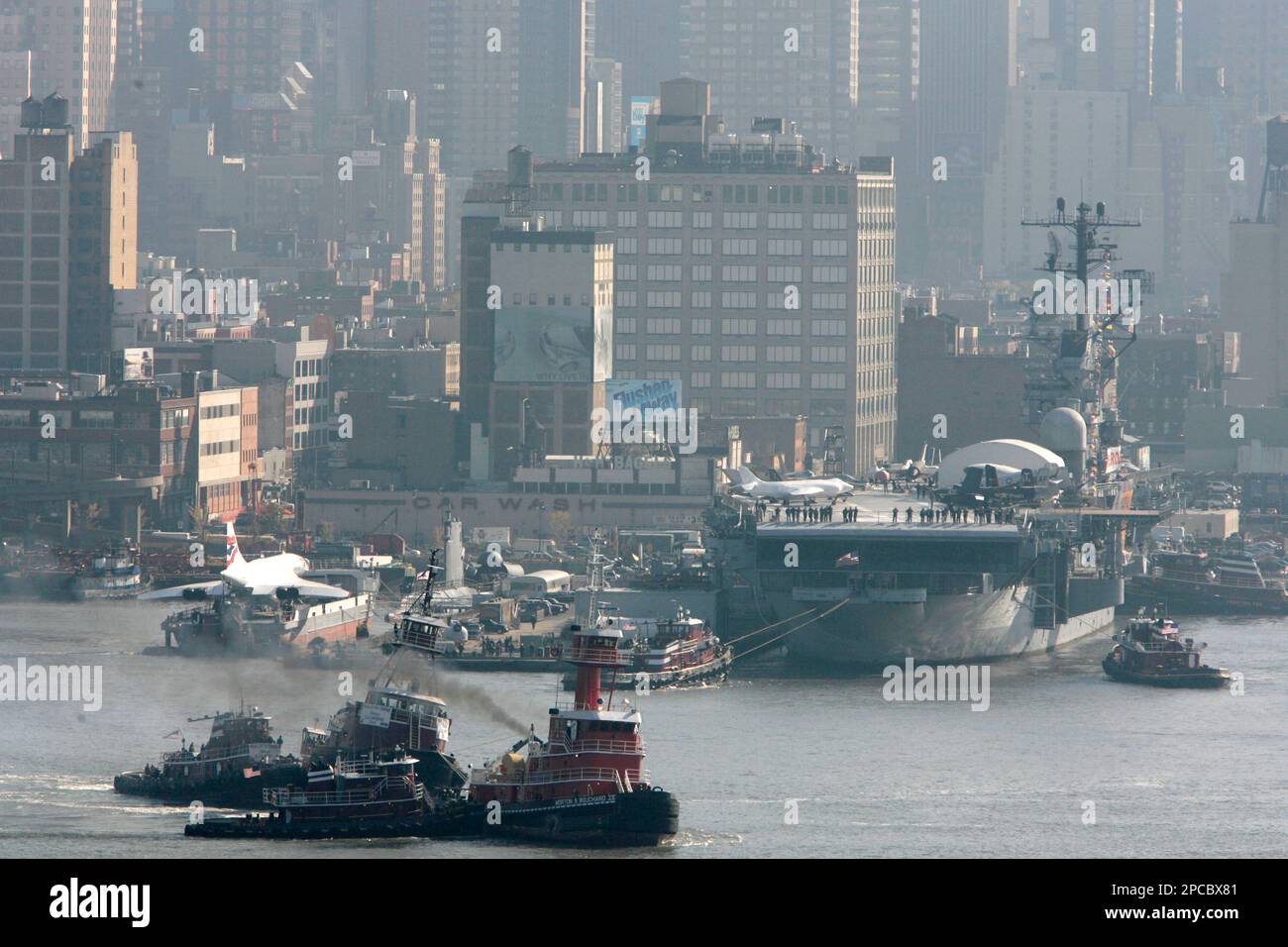 The USS Intrepid is pulled by tugboats in New York, Monday, Nov. 6 ...