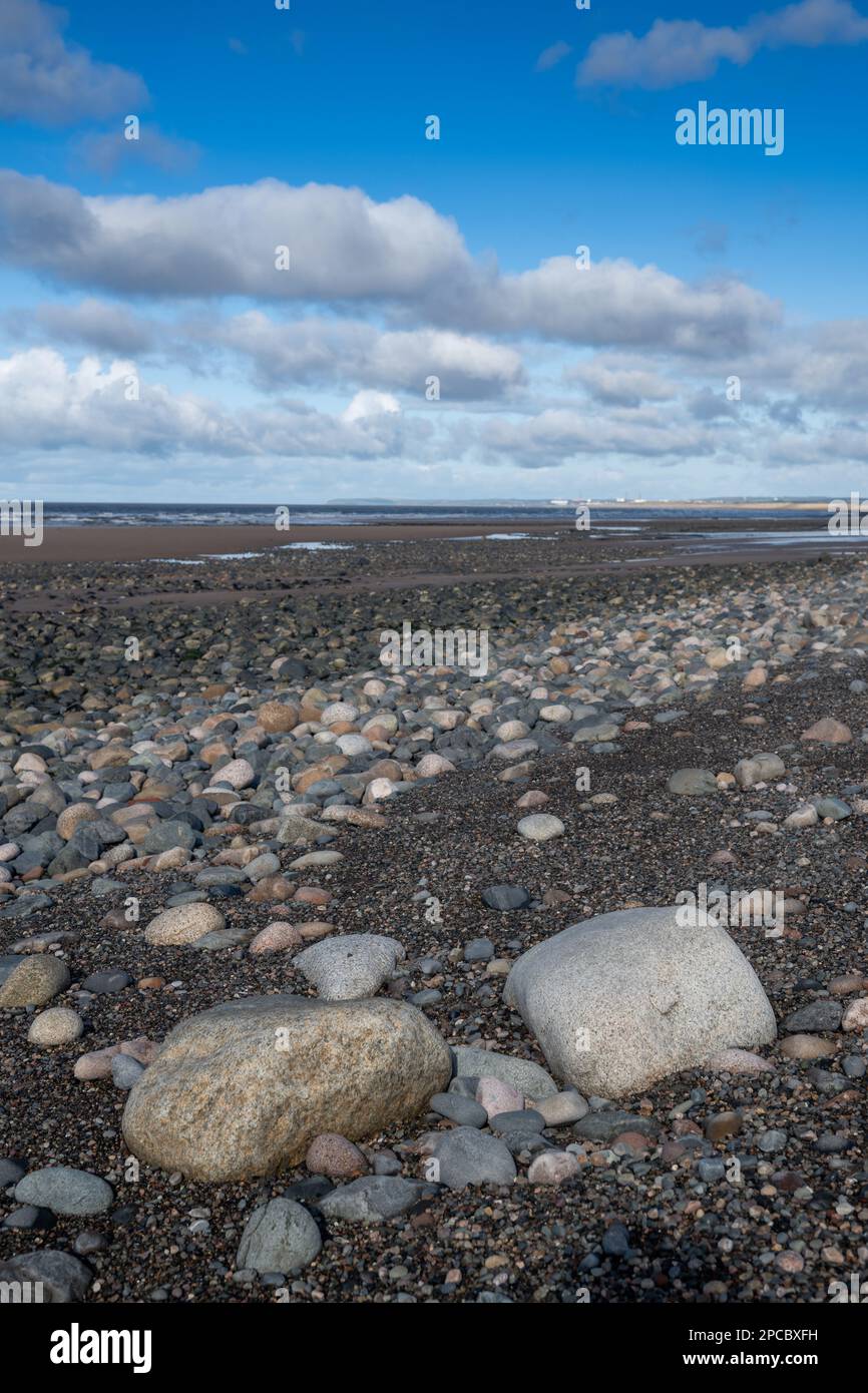 Waves lapping onto a stony beach off Bootle in Cumbria on the coast of ...