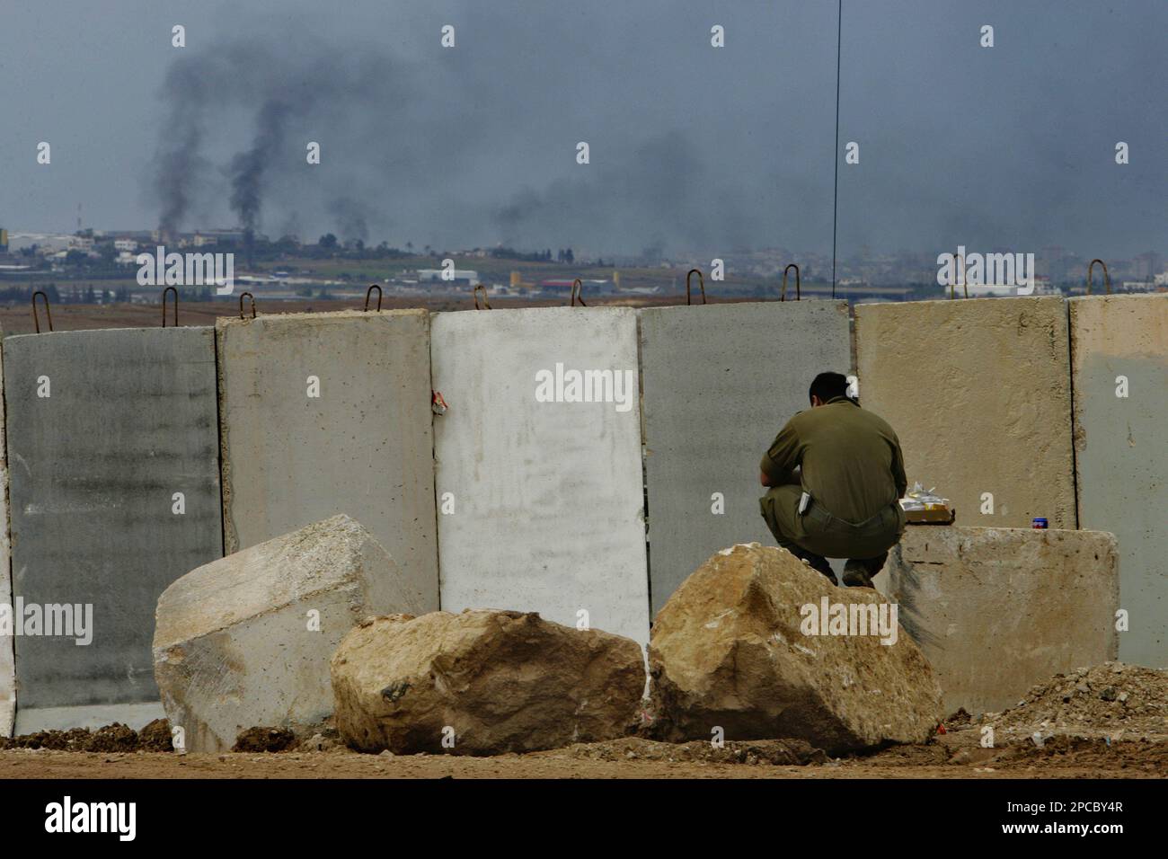 An Israeli soldier is seen behind a concrete blockade at an army ...