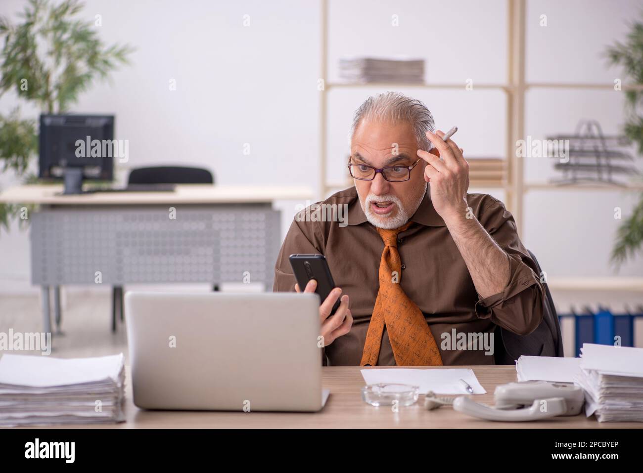 Old businessman employee smoking cigarette at workplace Stock Photo - Alamy