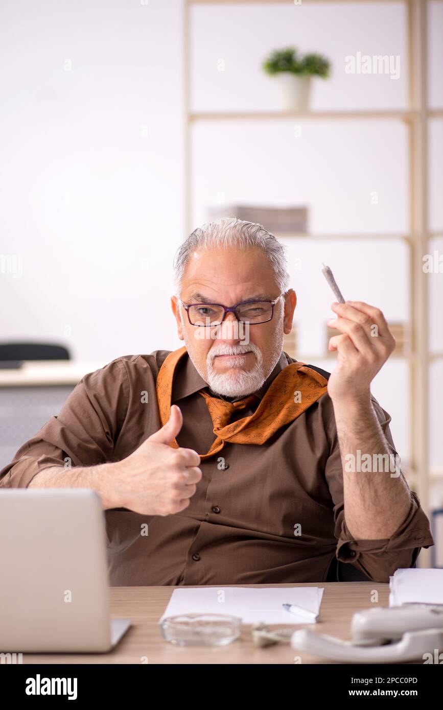 Old businessman employee smoking cigarette at workplace Stock Photo - Alamy