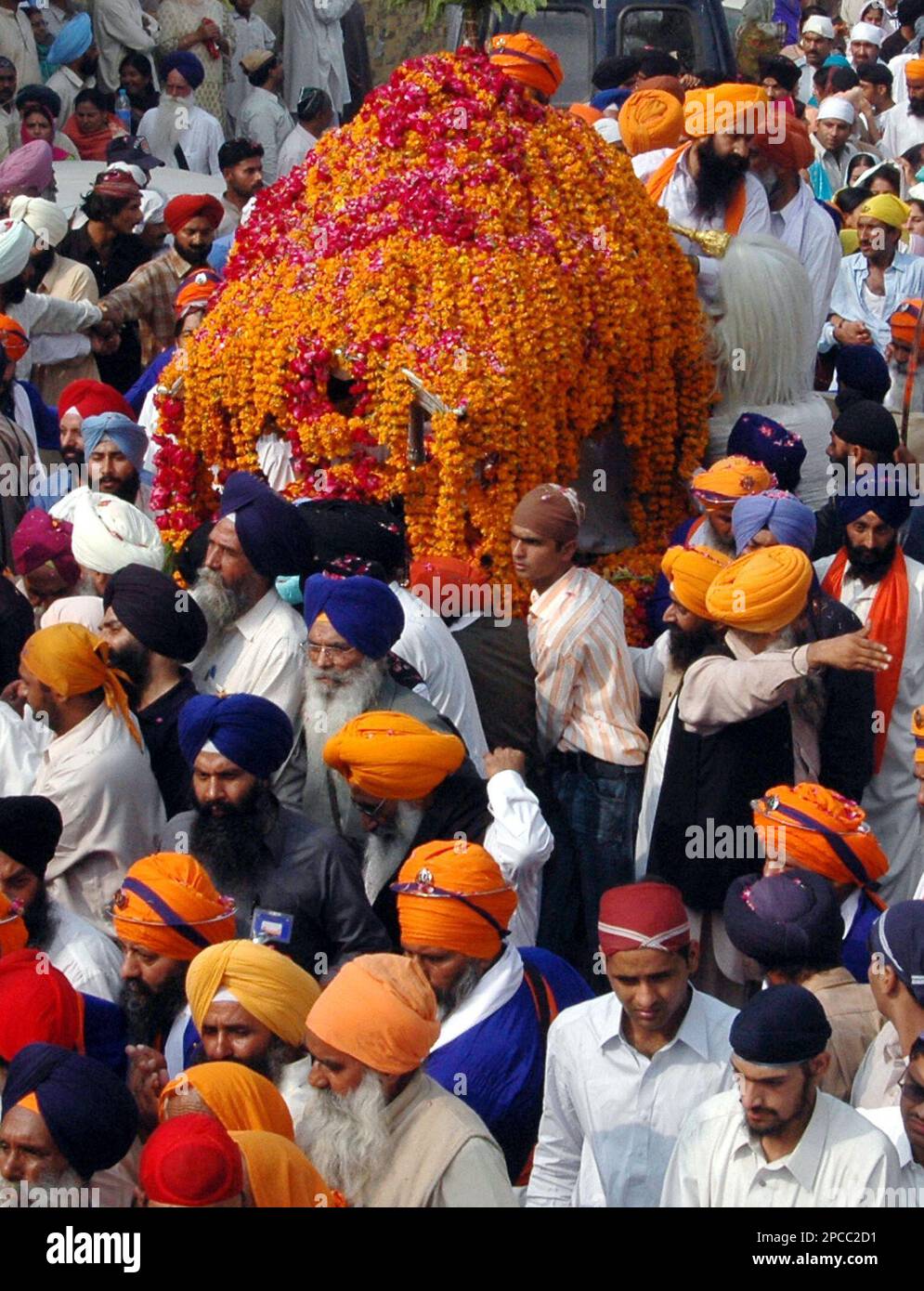 Sikh pilgrims bring Palkee, or a bunch of flowers, to pay homage to ...