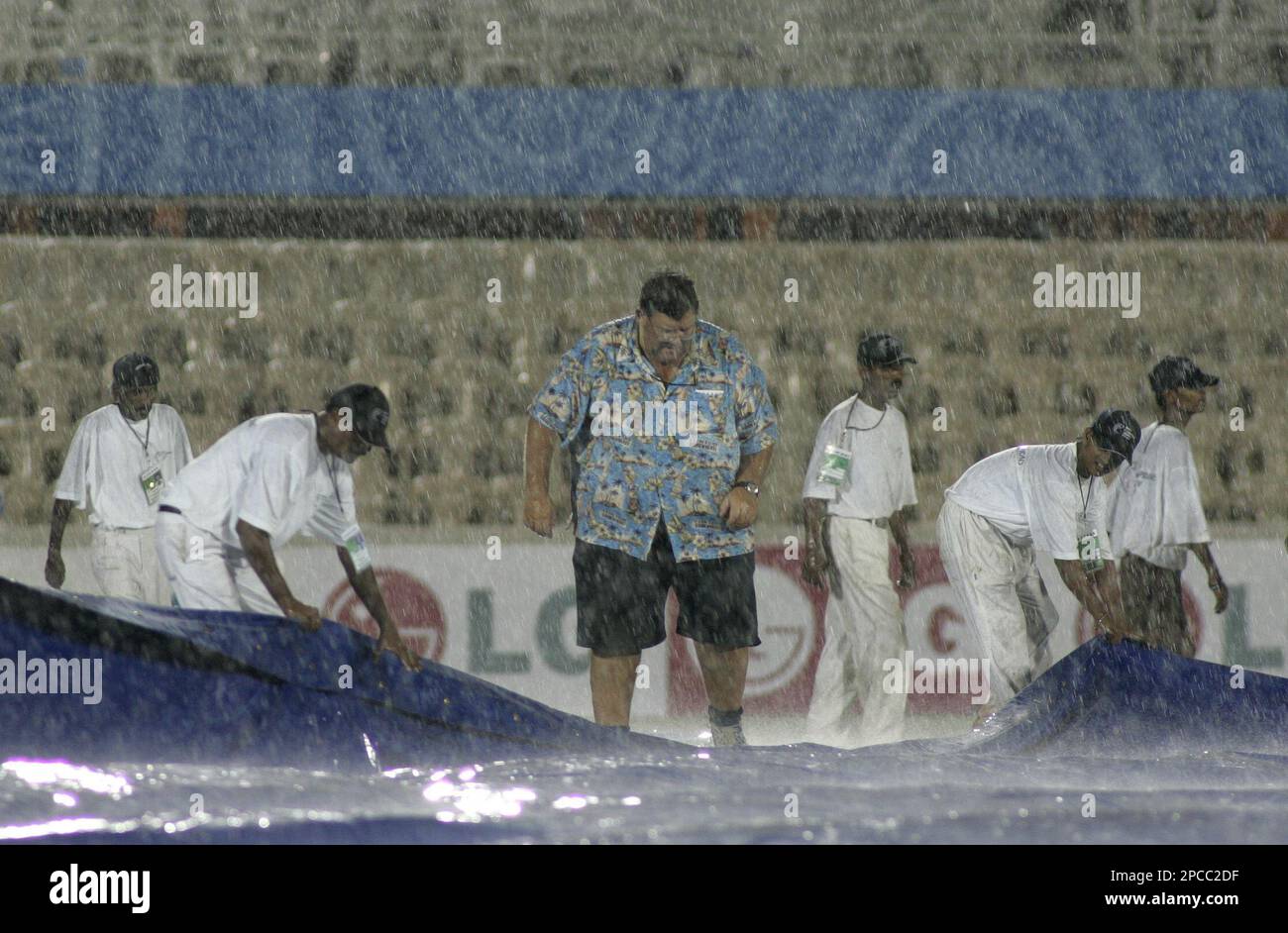 Pitch curator Andy Atkinson, center, ensures protection for the playing ...