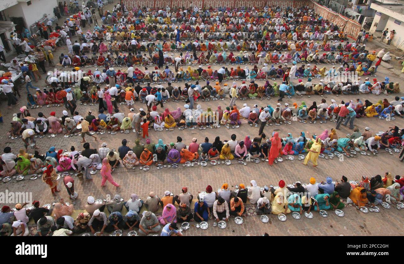 Sikh devotees participate in the Guru ka Langar, a community kitchen ...