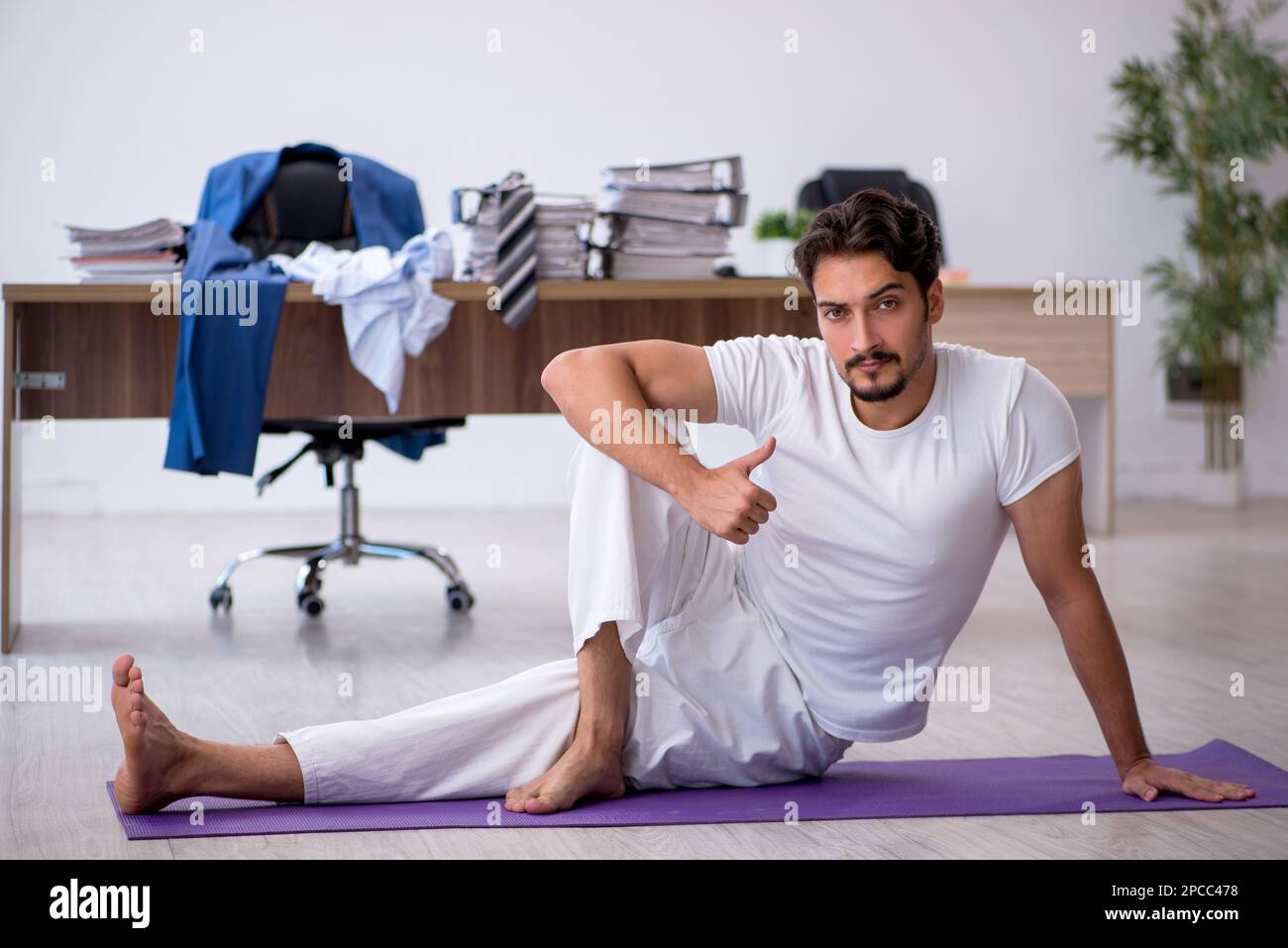 Young businessman employee doing sport exercises at workplace Stock ...