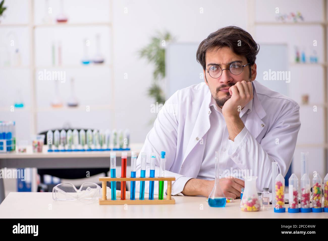 Young chemist in drugs synthesis concept Stock Photo - Alamy
