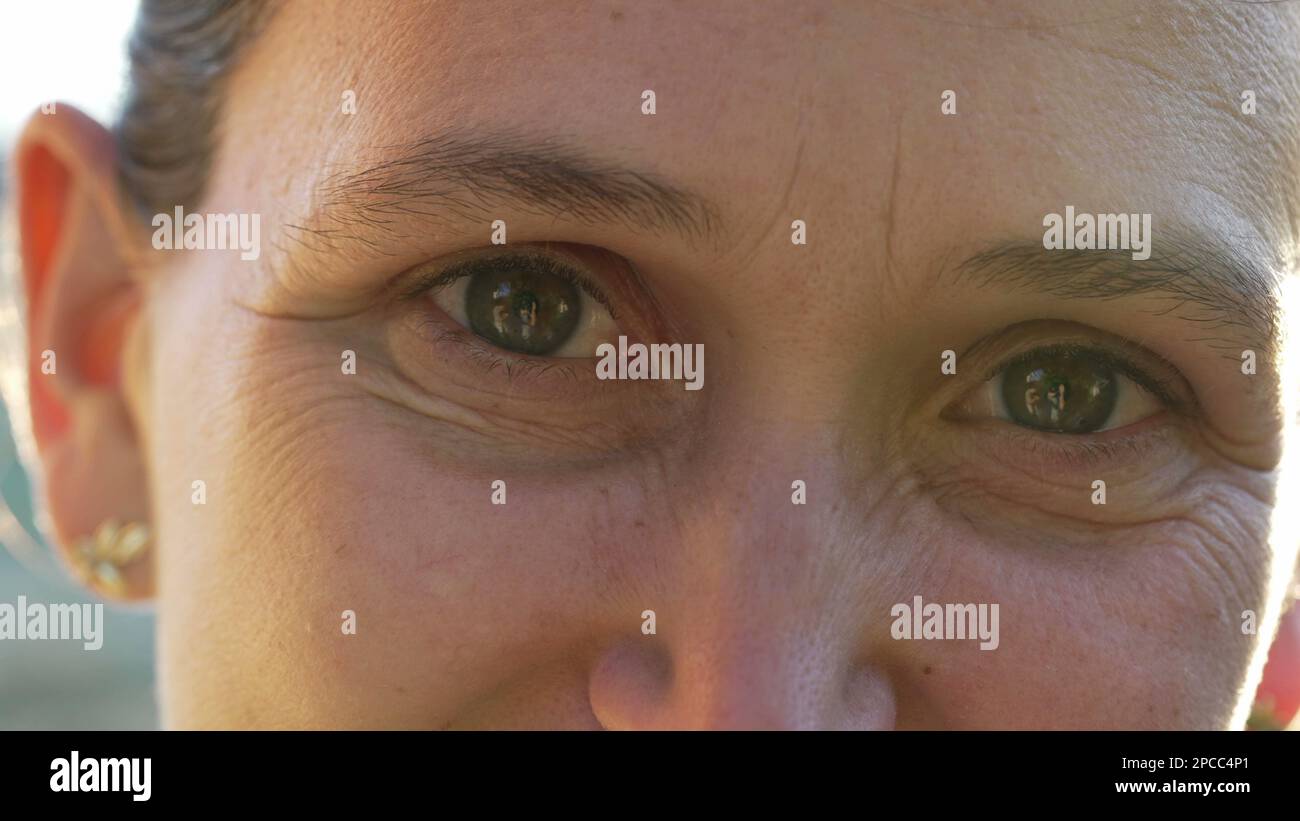 Woman eyes looking at camera outdoors. Macro close up of 40 years old ...