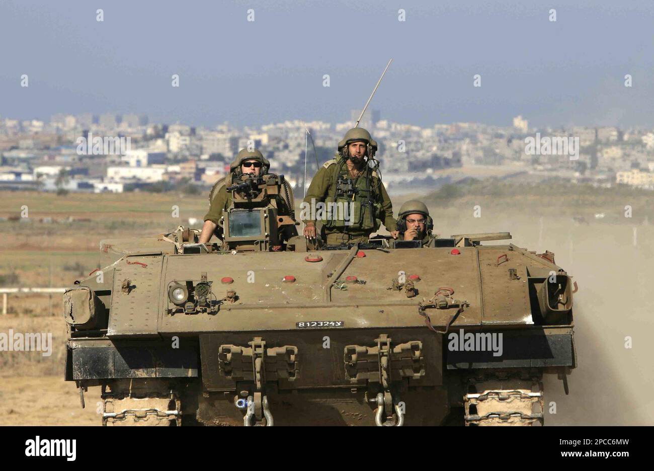 An Israeli armored vehicle crosses back into Israel from the Gaza Strip ...
