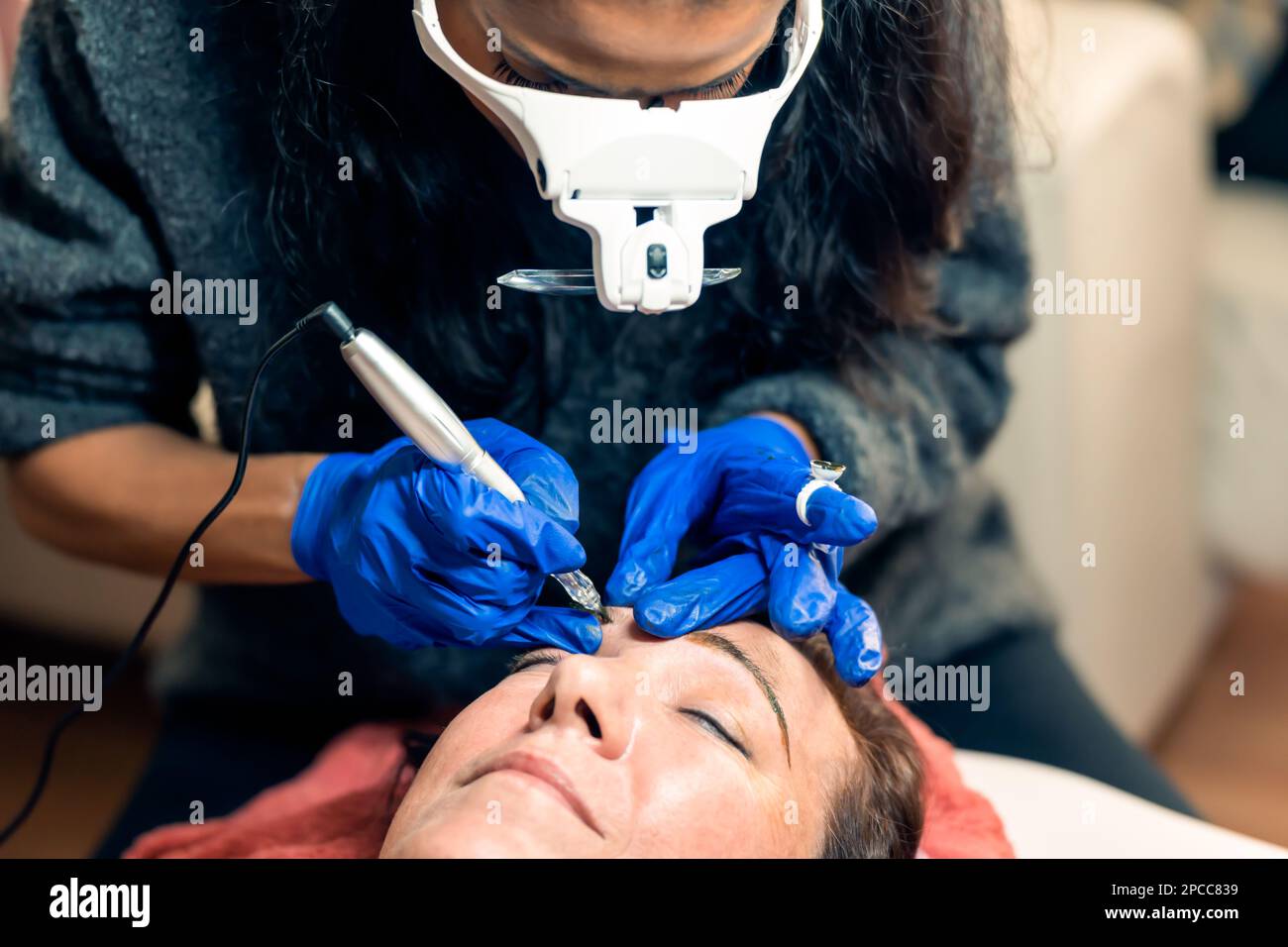 Professional microblading master in latex gloves and magnification ...