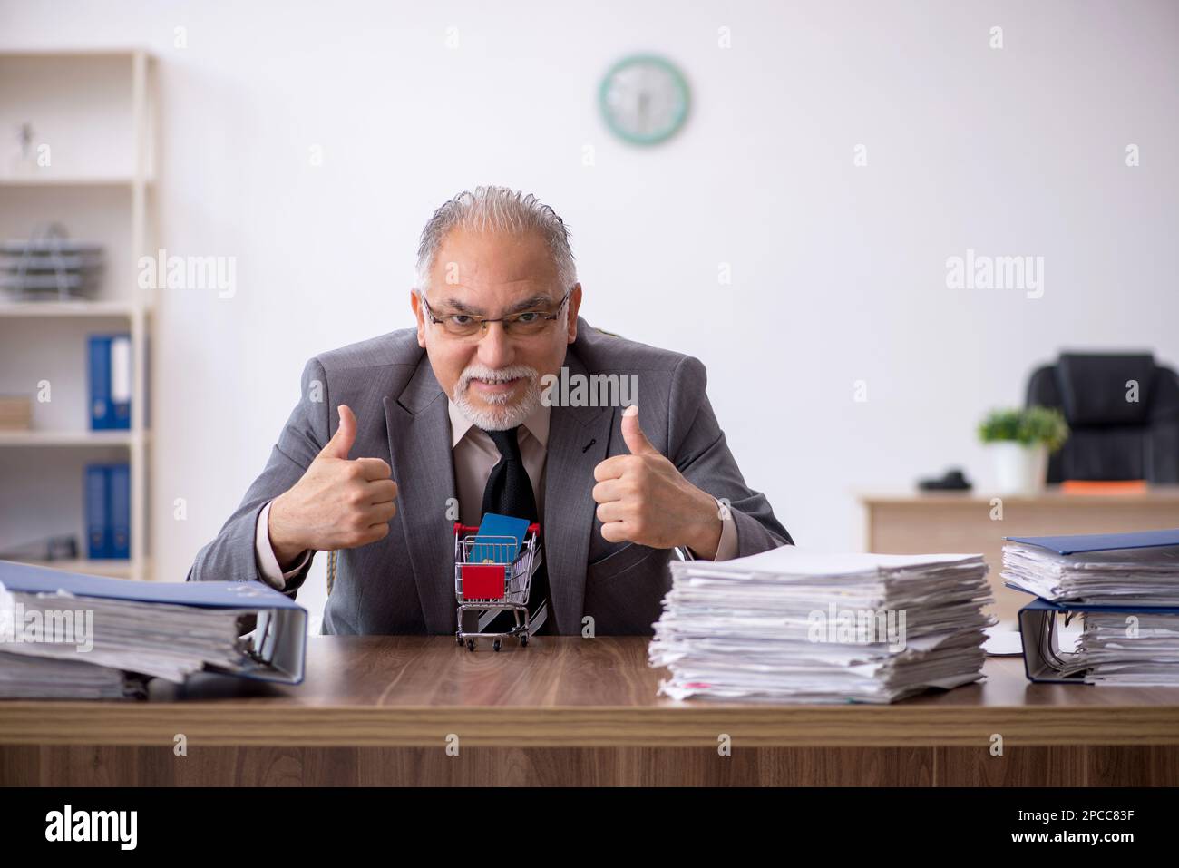 Old male boss holding credit card at workplace Stock Photo - Alamy